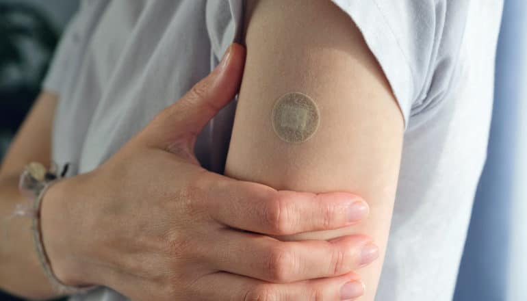 A girl or woman holds her hand, which is covered with a plaster or ...